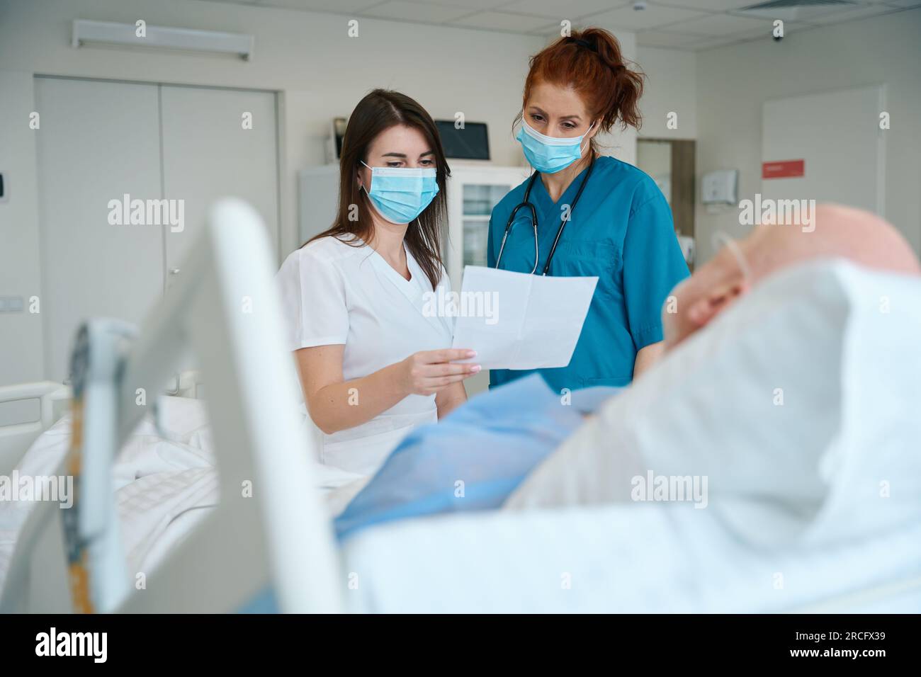 Hospital staff discuss paper hi-res stock photography and images - Alamy