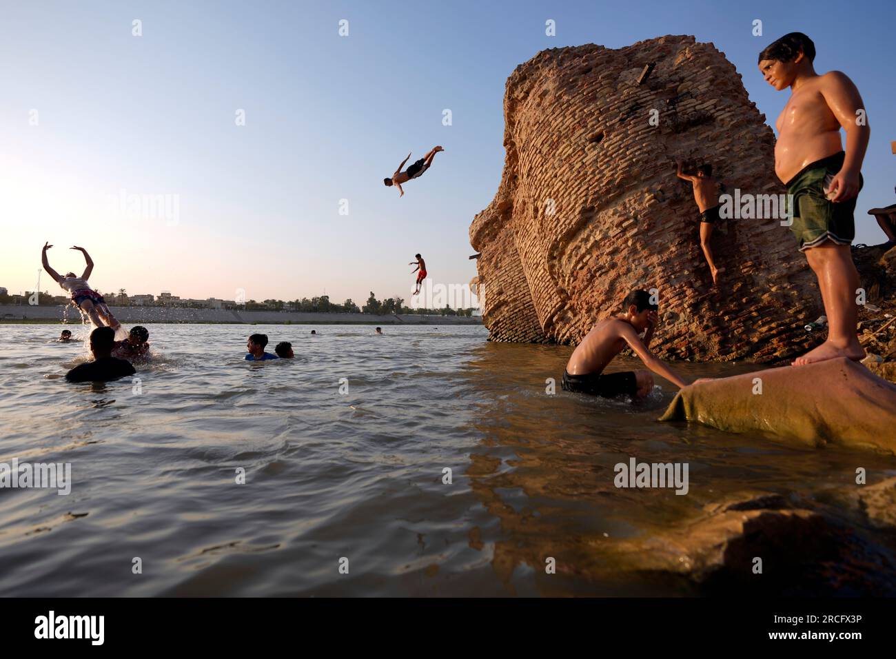 Iraqi men and their sons swim in the Tigris river to beat the heat in ...