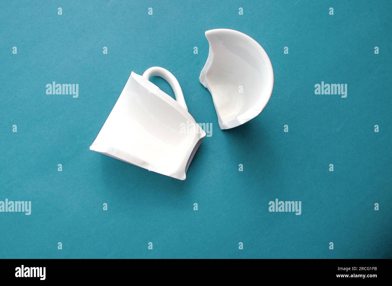 Closeup of a cup broken in half, showing the pieces in contrast to the ...