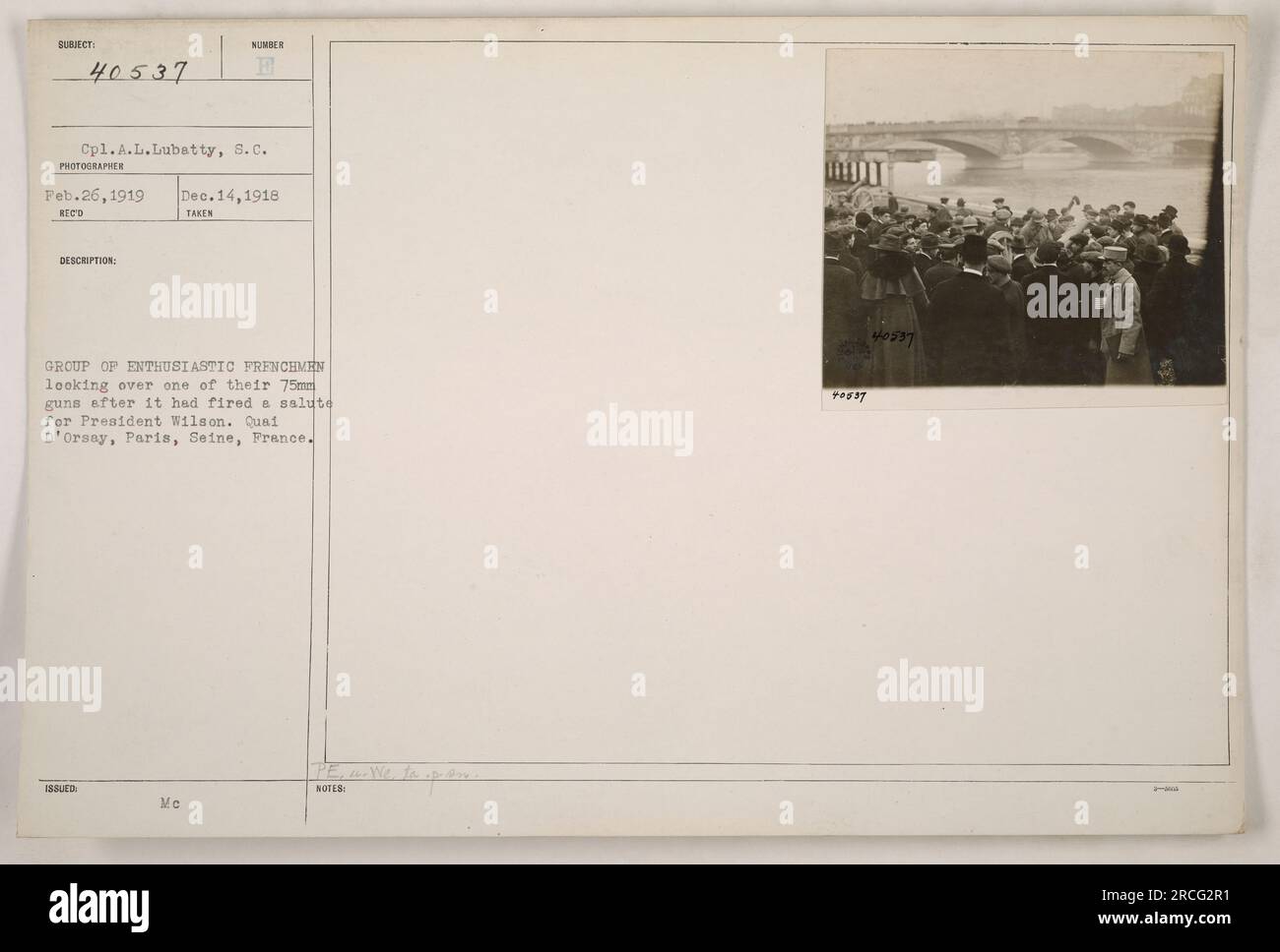 A group of enthusiastic Frenchmen looking over a 75mm gun after firing ...