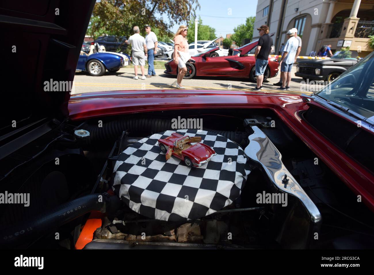 A Corvette model is displayed on the engine of a 1959 Chevy Corvette ...