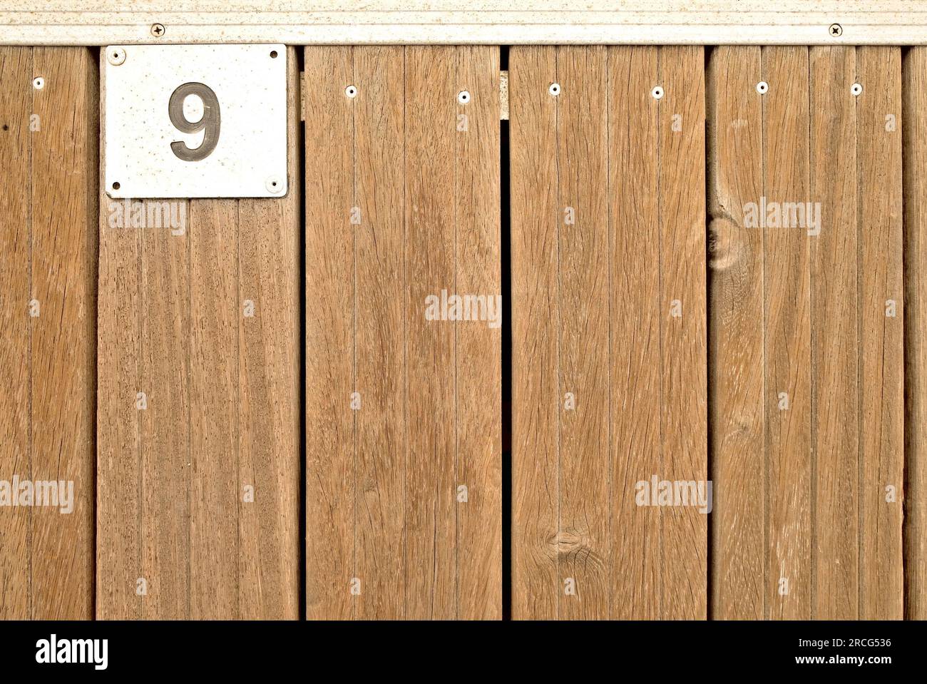 9, number nine, metal plate on wooden teak deck Stock Photo - Alamy