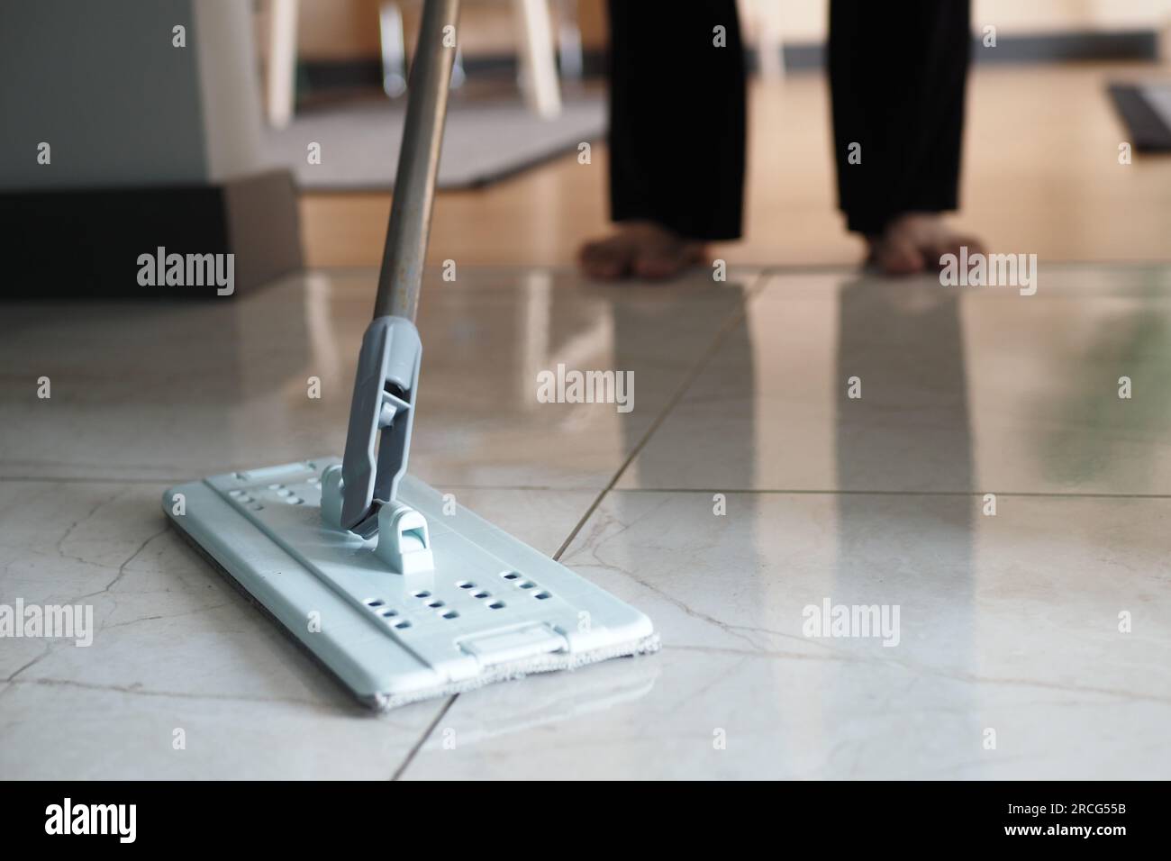 cleaning tiles floor with mop Stock Photo - Alamy
