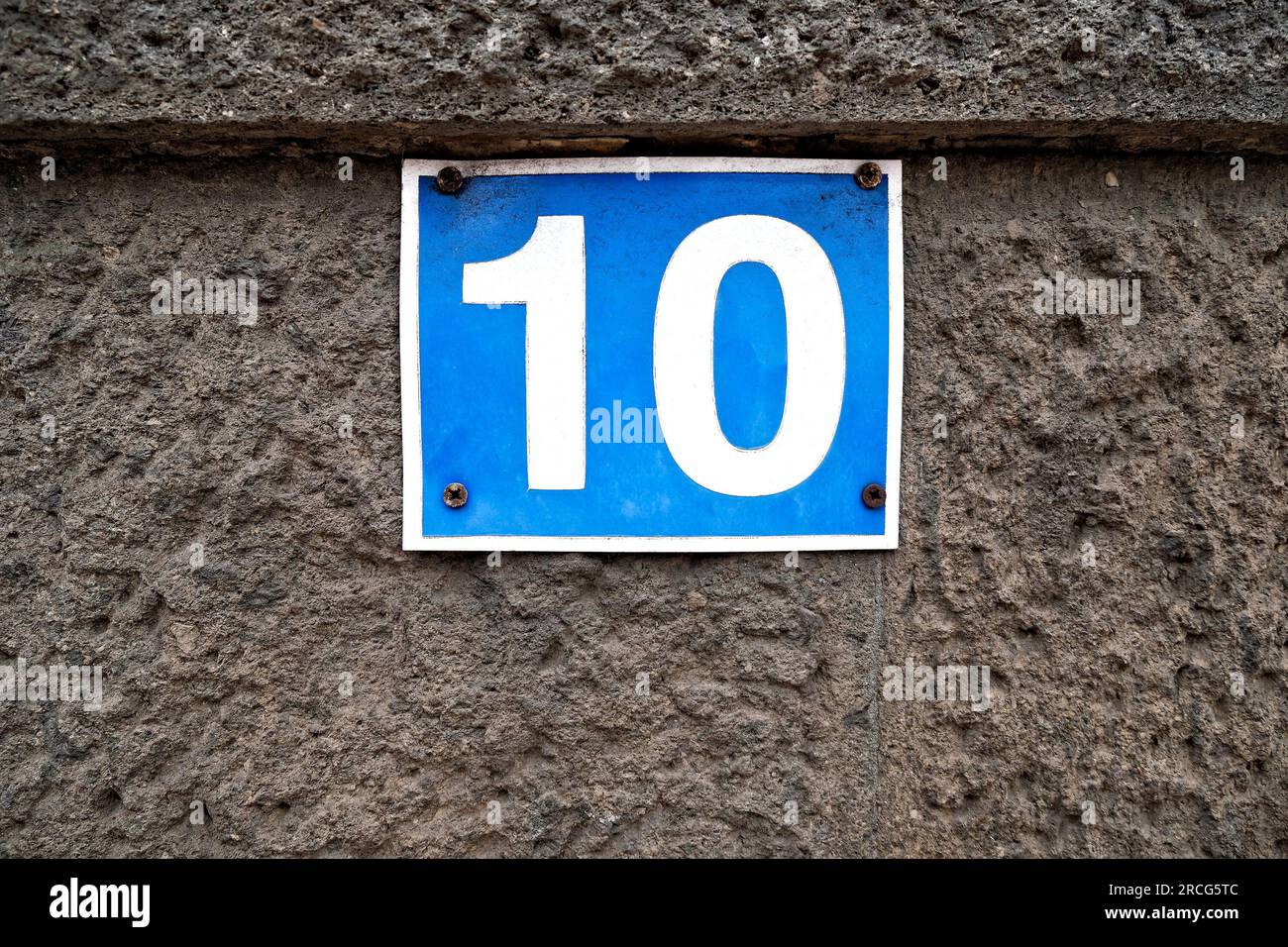 Number 10, ten, blue plate on warm stone background Stock Photo - Alamy