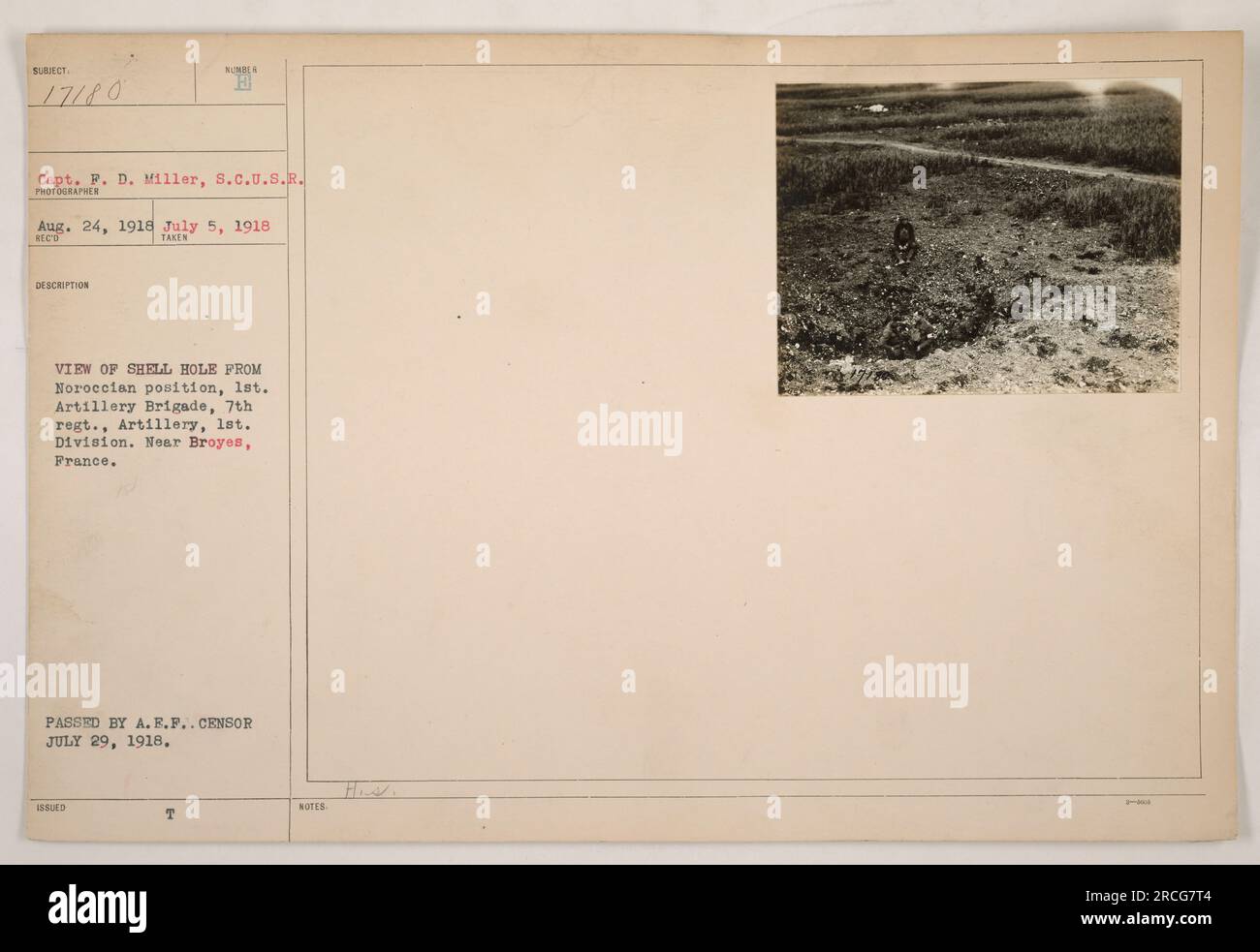 American soldiers inspect a large shell hole in the ground. This photo ...
