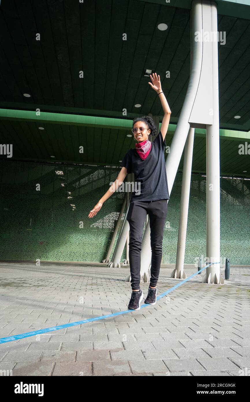 Colombian Woman Wearing Black Pants and a T-shirt is Walking on a Blue Rope Practicing Slack ...