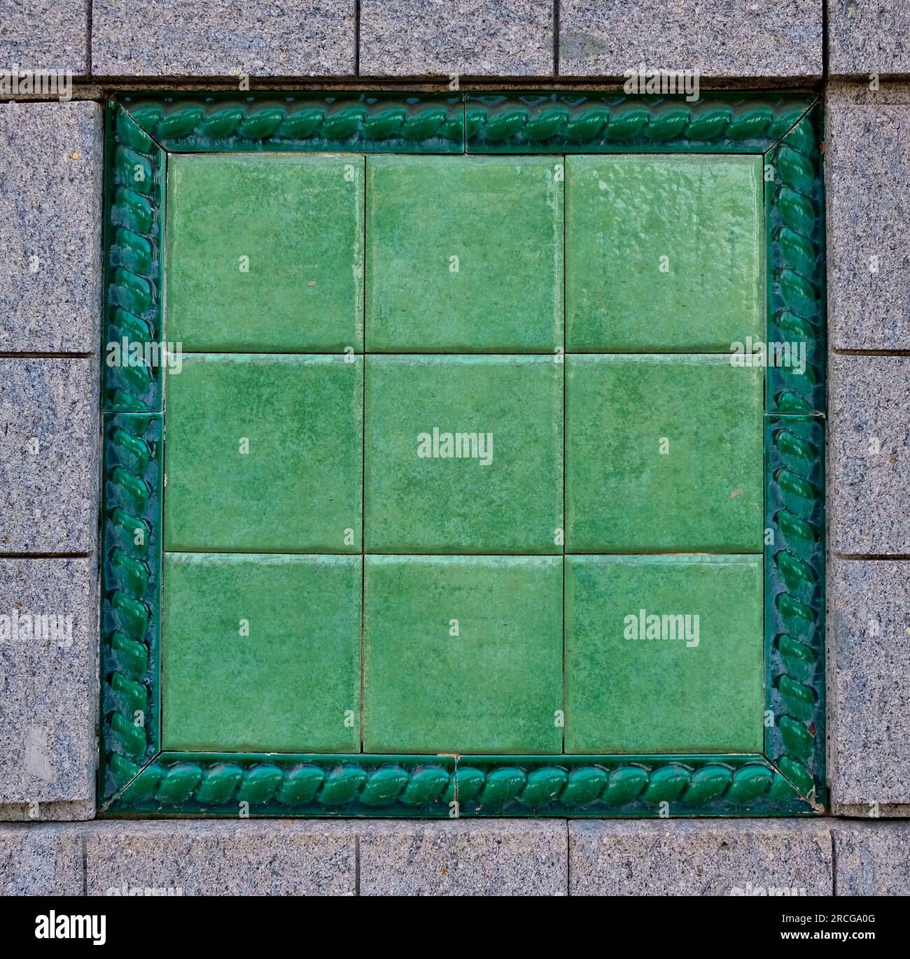 Nine green glazed glossy tiles with floral dark frame, simple empty ...