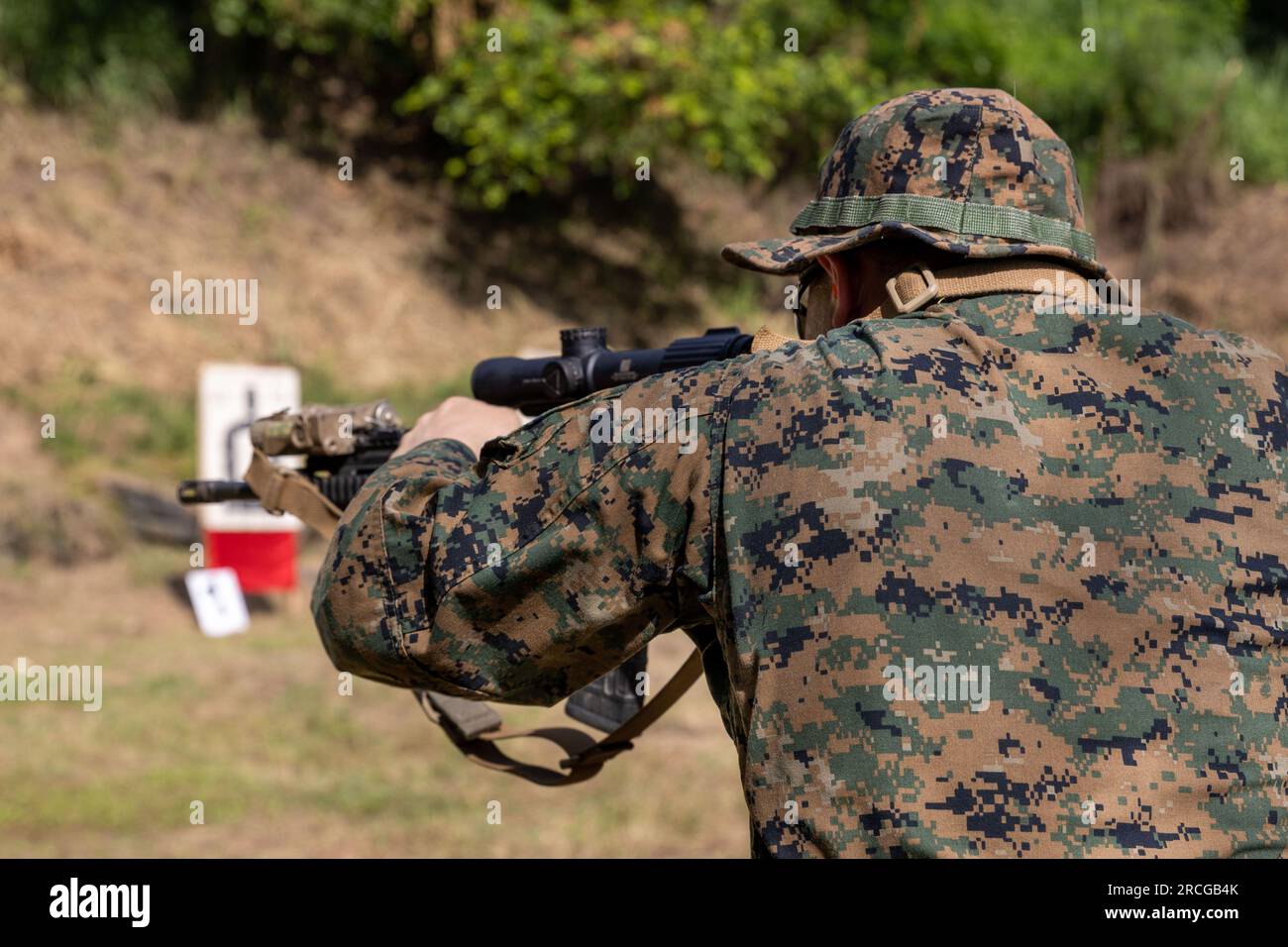 A U.S. Marine aims at a target for a headshot while conducting a marksmanship course during ...