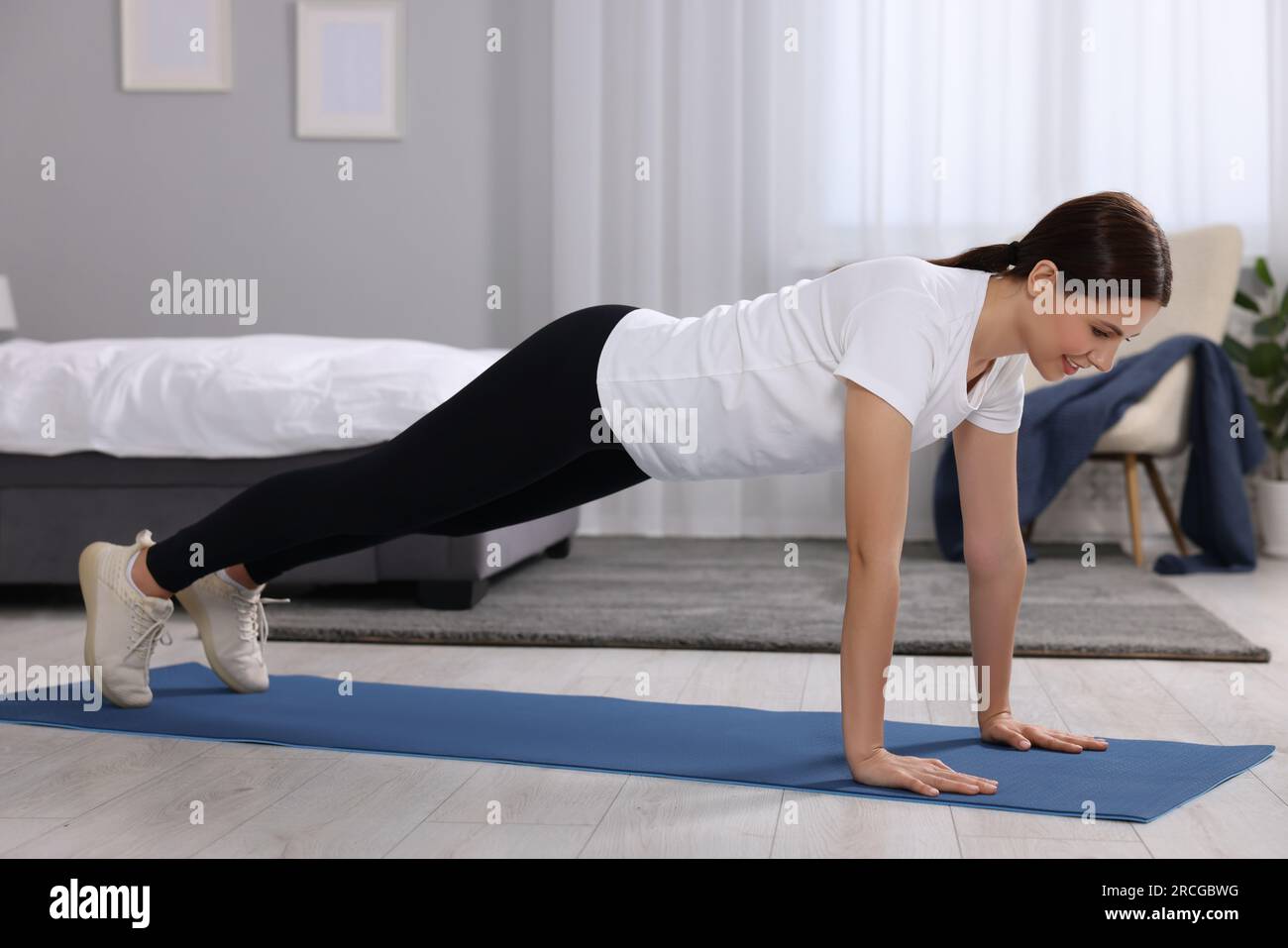 Happy woman doing plank exercise at home. Morning routine Stock Photo ...