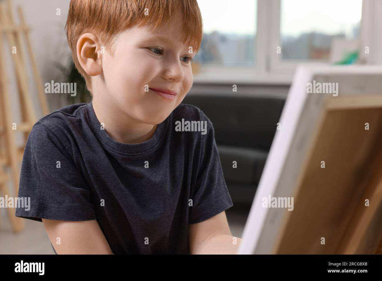 Little boy painting on canvas in studio Stock Photo - Alamy