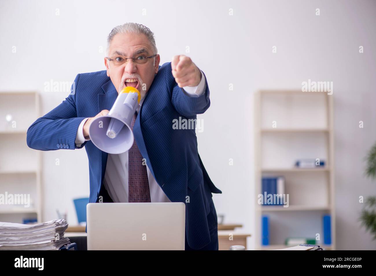 Old employee holding megaphone in the office Stock Photo - Alamy