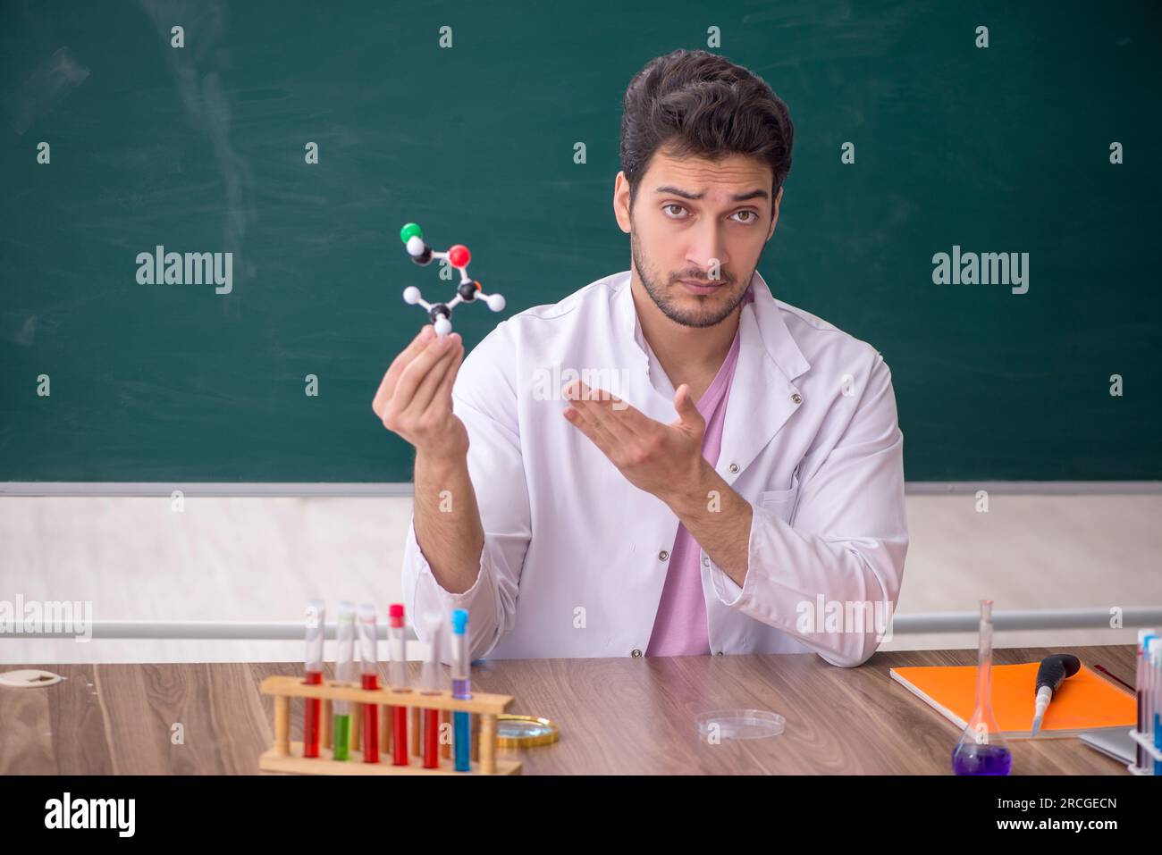 Young chemistry teacher sitting in the classroom Stock Photo - Alamy