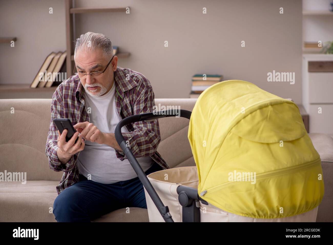Old man looking after baby at home Stock Photo - Alamy
