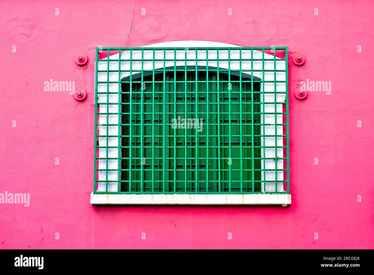 Green barred window in a bright pink wall Stock Photo - Alamy
