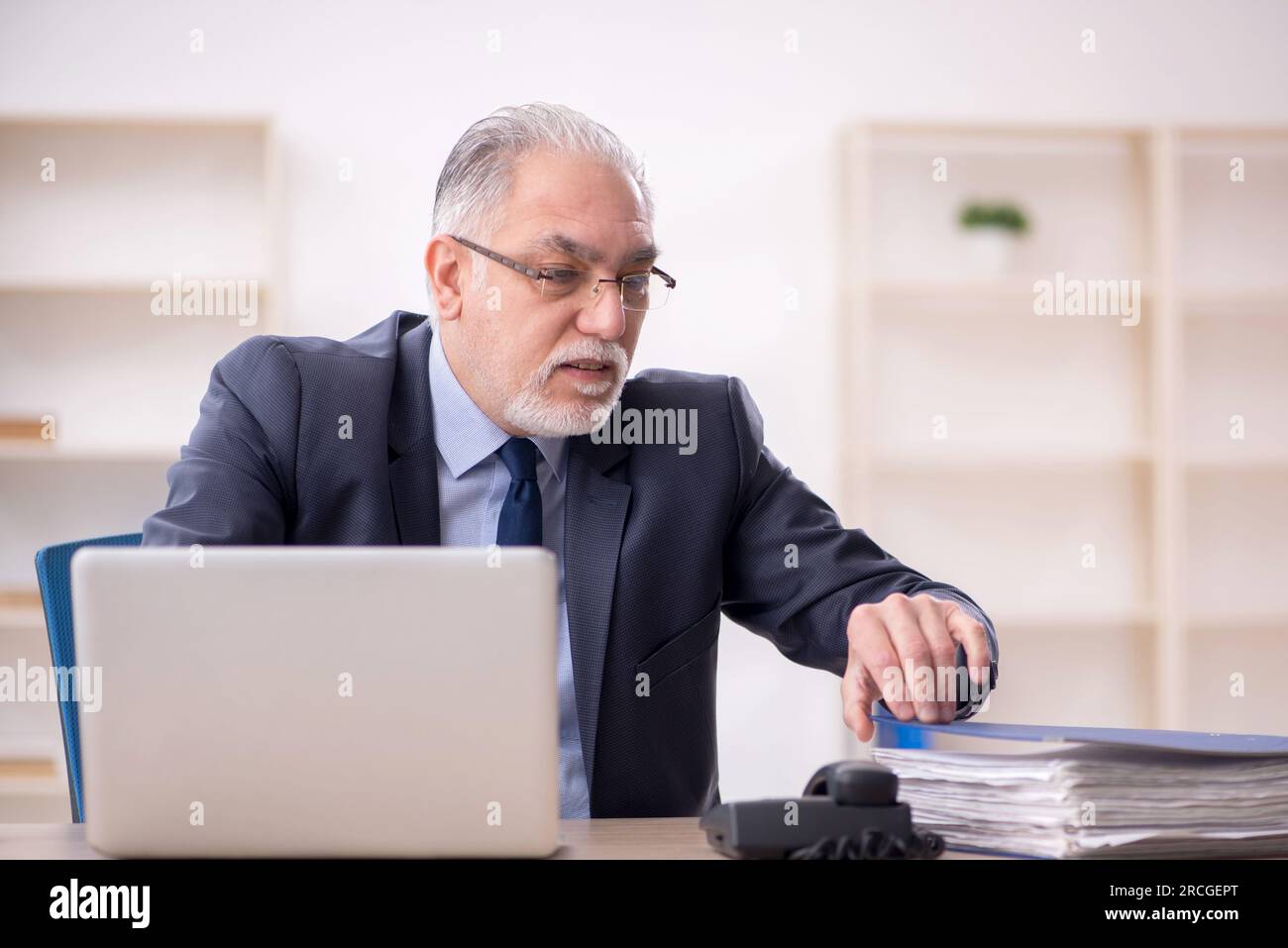 Old employee working at workplace Stock Photo - Alamy
