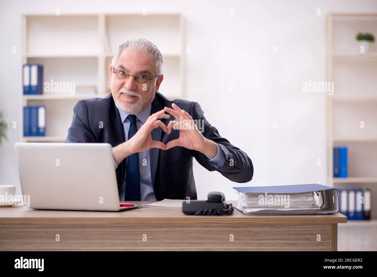 Old employee working at workplace Stock Photo - Alamy