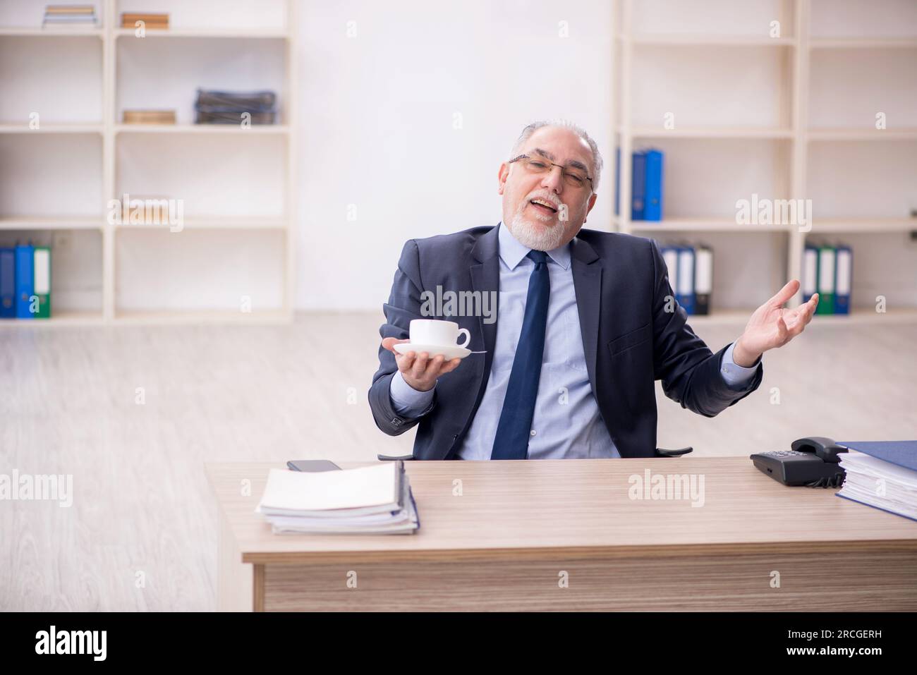 Old employee drinking tea at workplace Stock Photo - Alamy