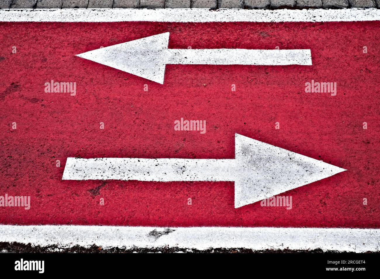 Left and right white dirrection arrows on neon red surface of a city ...