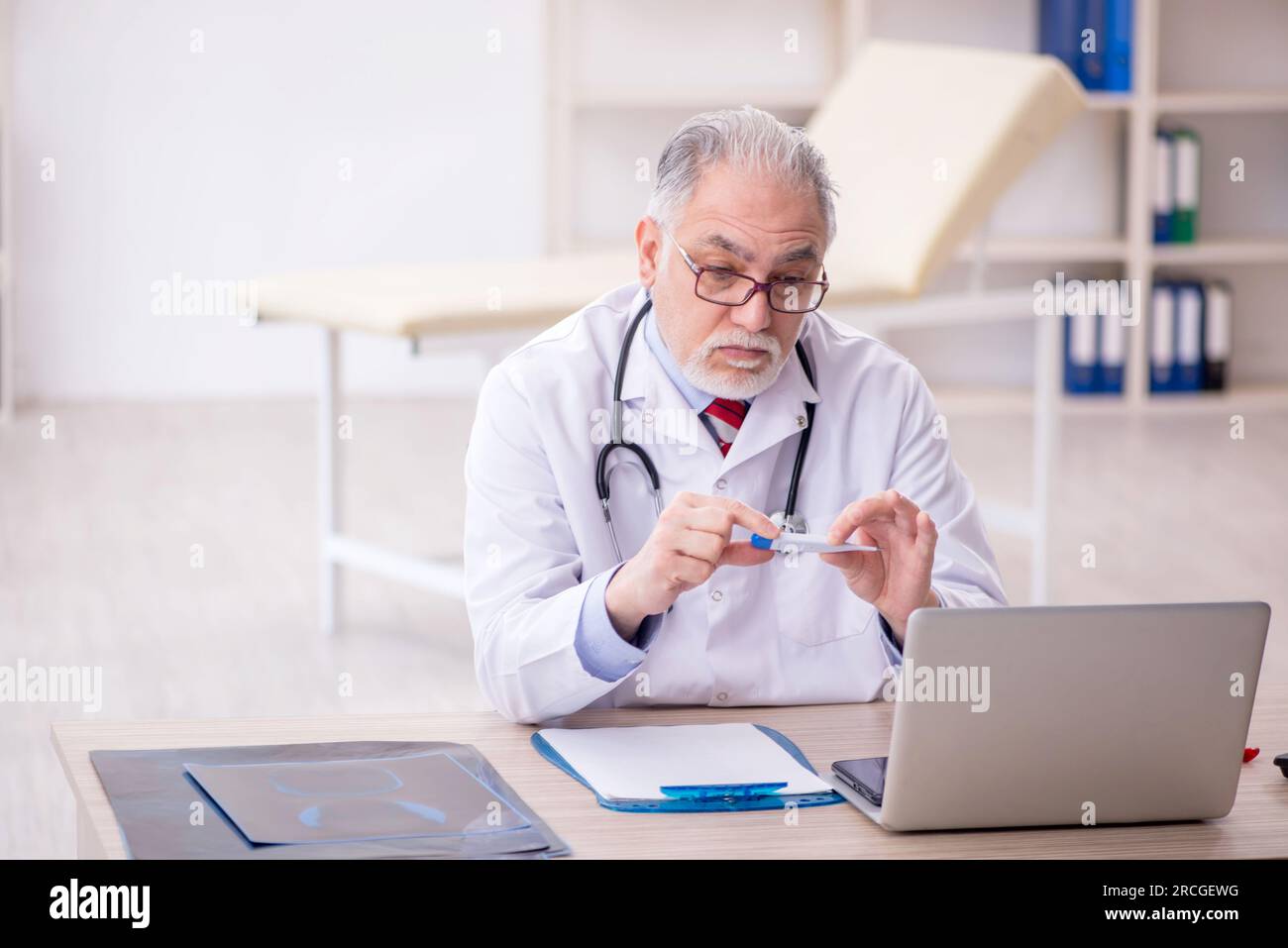 Old doctor working at the hospital Stock Photo - Alamy
