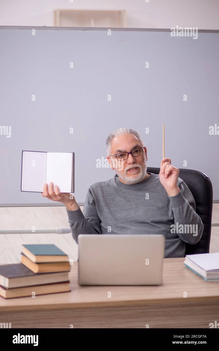 Old teacher in the classroom Stock Photo - Alamy