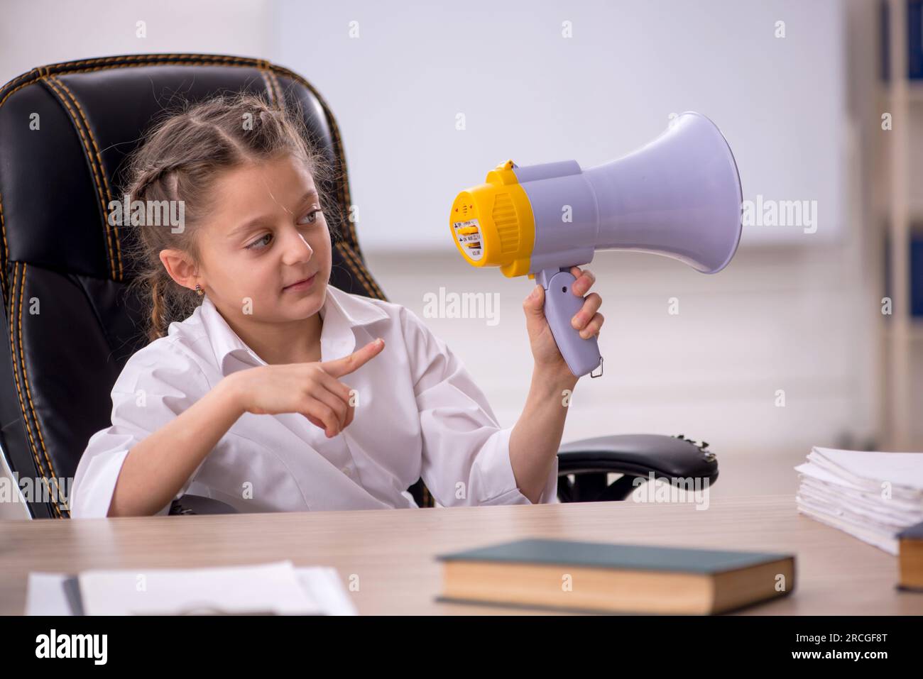 Little girl holding megaphone in the classroom Stock Photo - Alamy