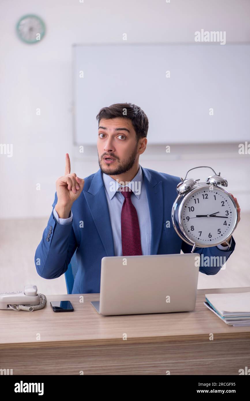 Young employee in time management concept Stock Photo - Alamy