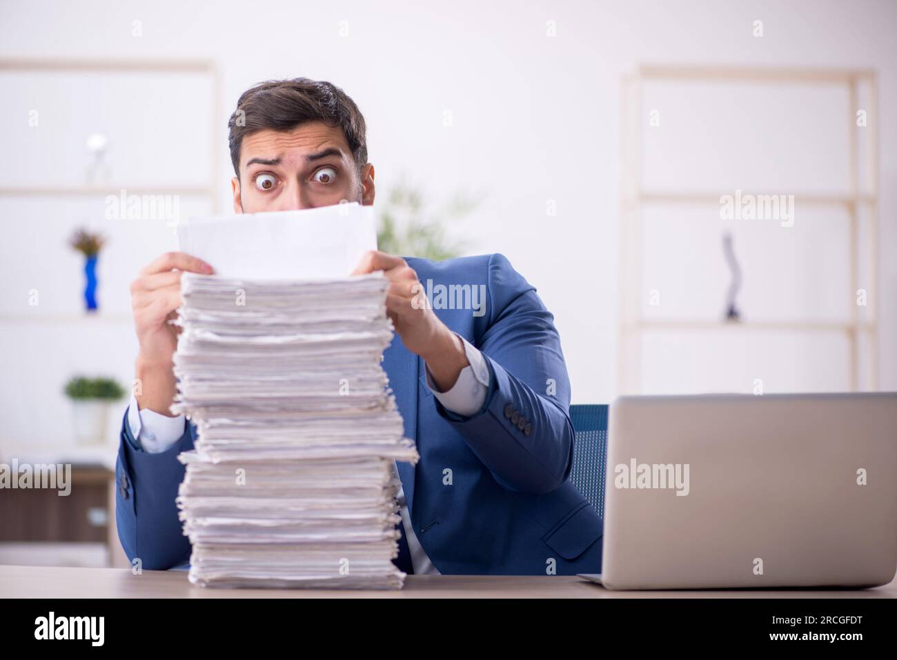 Young employee and too much work in the office Stock Photo - Alamy