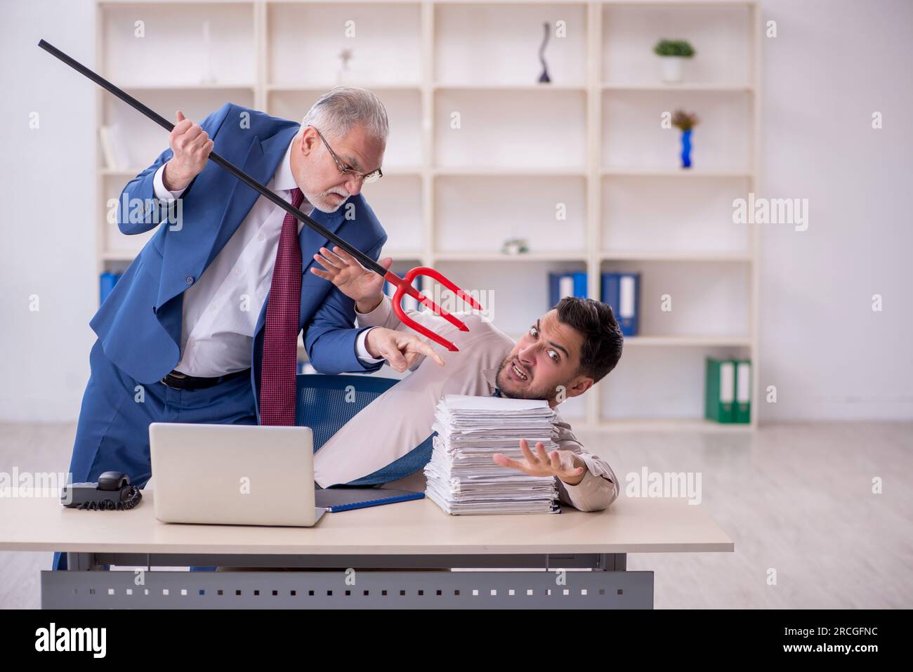 Old boss and young employee in bullying concept Stock Photo - Alamy