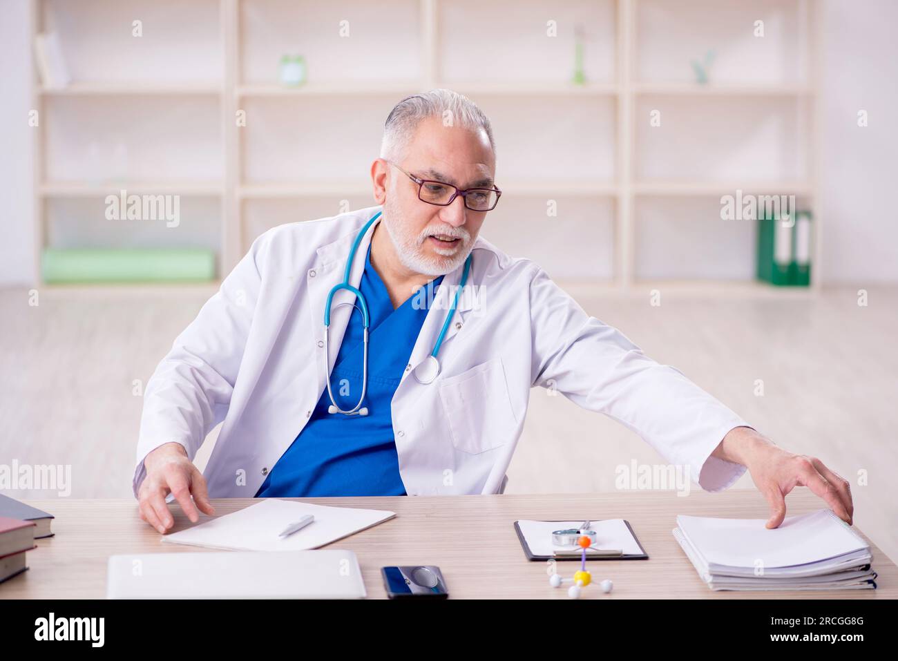 Old doctor sitting at the hospital Stock Photo - Alamy