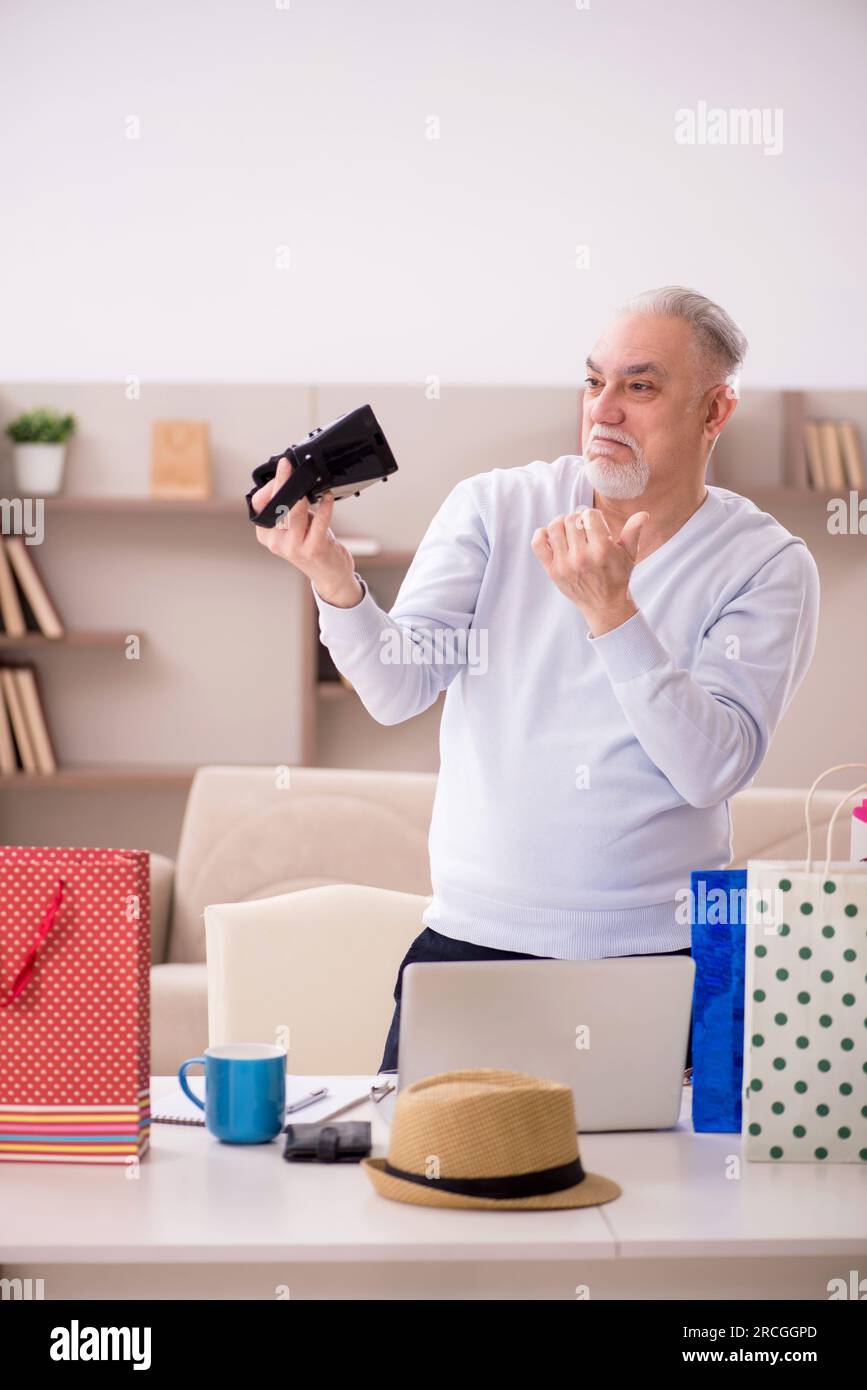 Old man with many bags in Christmas concept indoors Stock Photo - Alamy