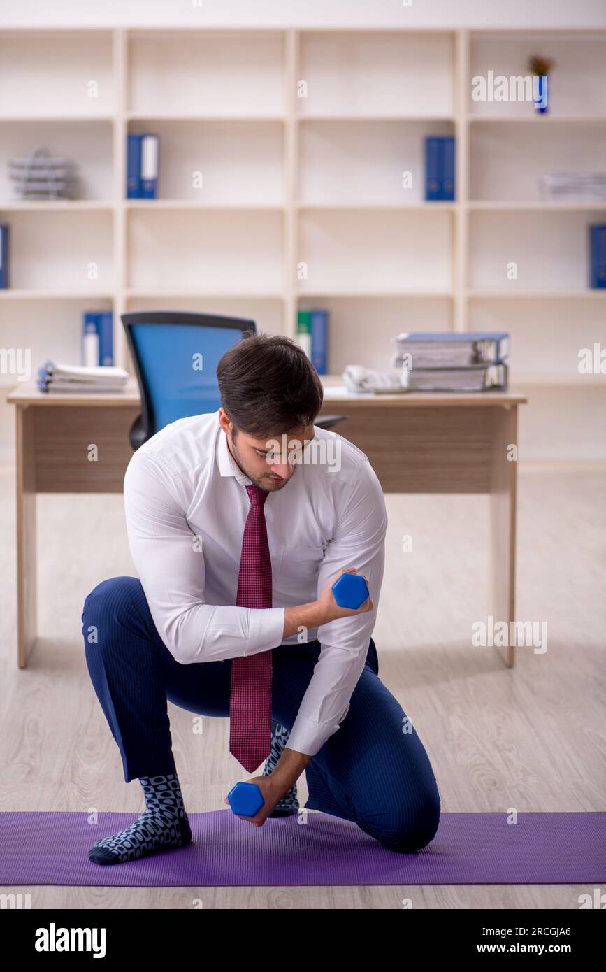 Young employee doing sport exercises during break Stock Photo - Alamy