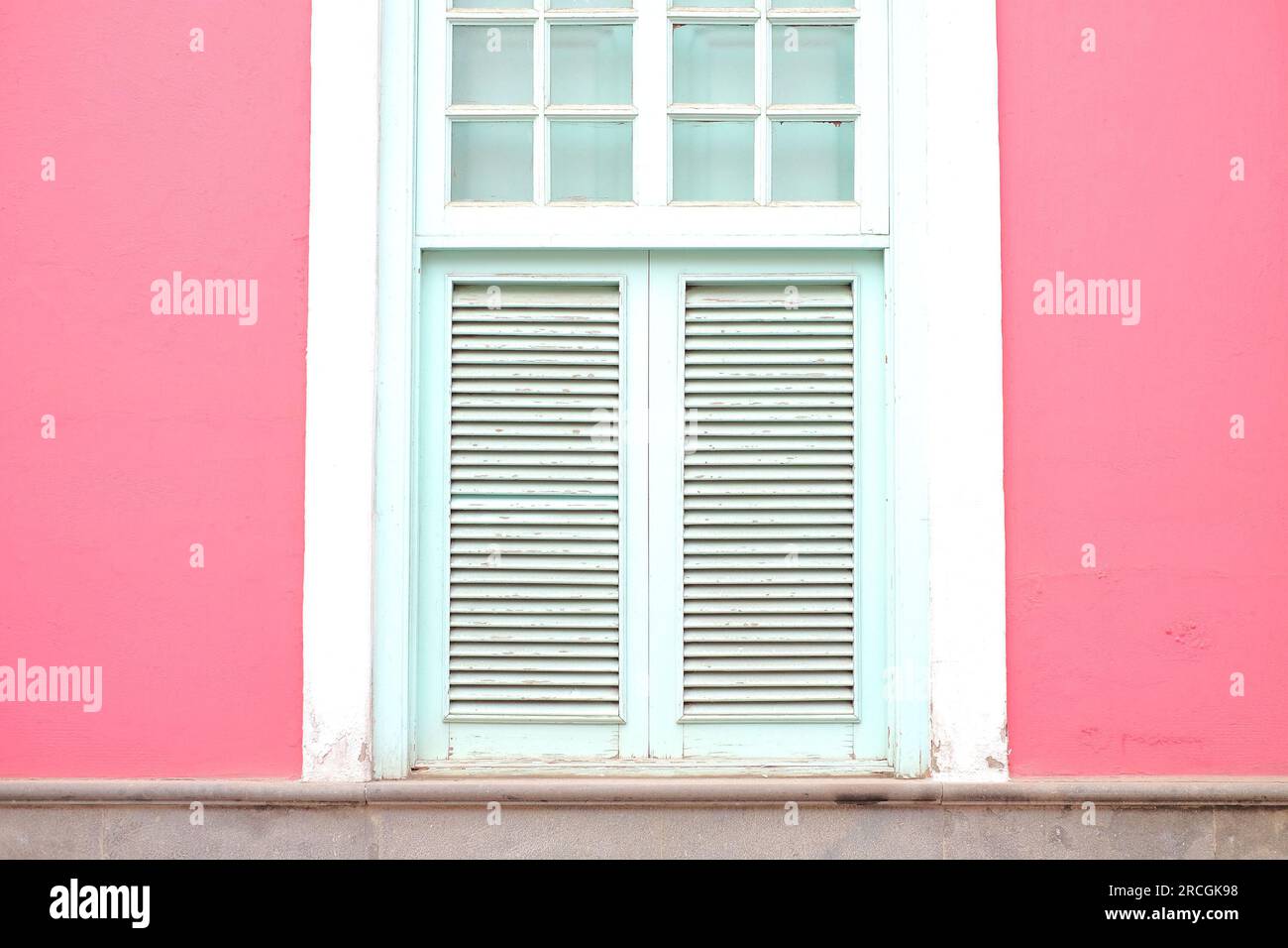Pale pink wall and white wooden frame window with venetian blinds Stock ...
