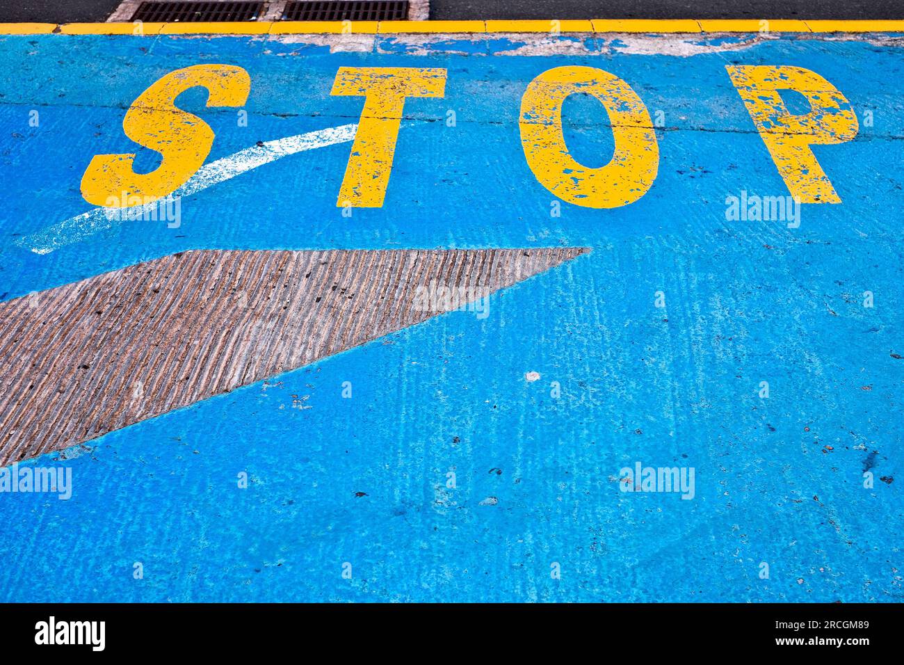 Yellow word STOP on blue background before entrance to a city ...