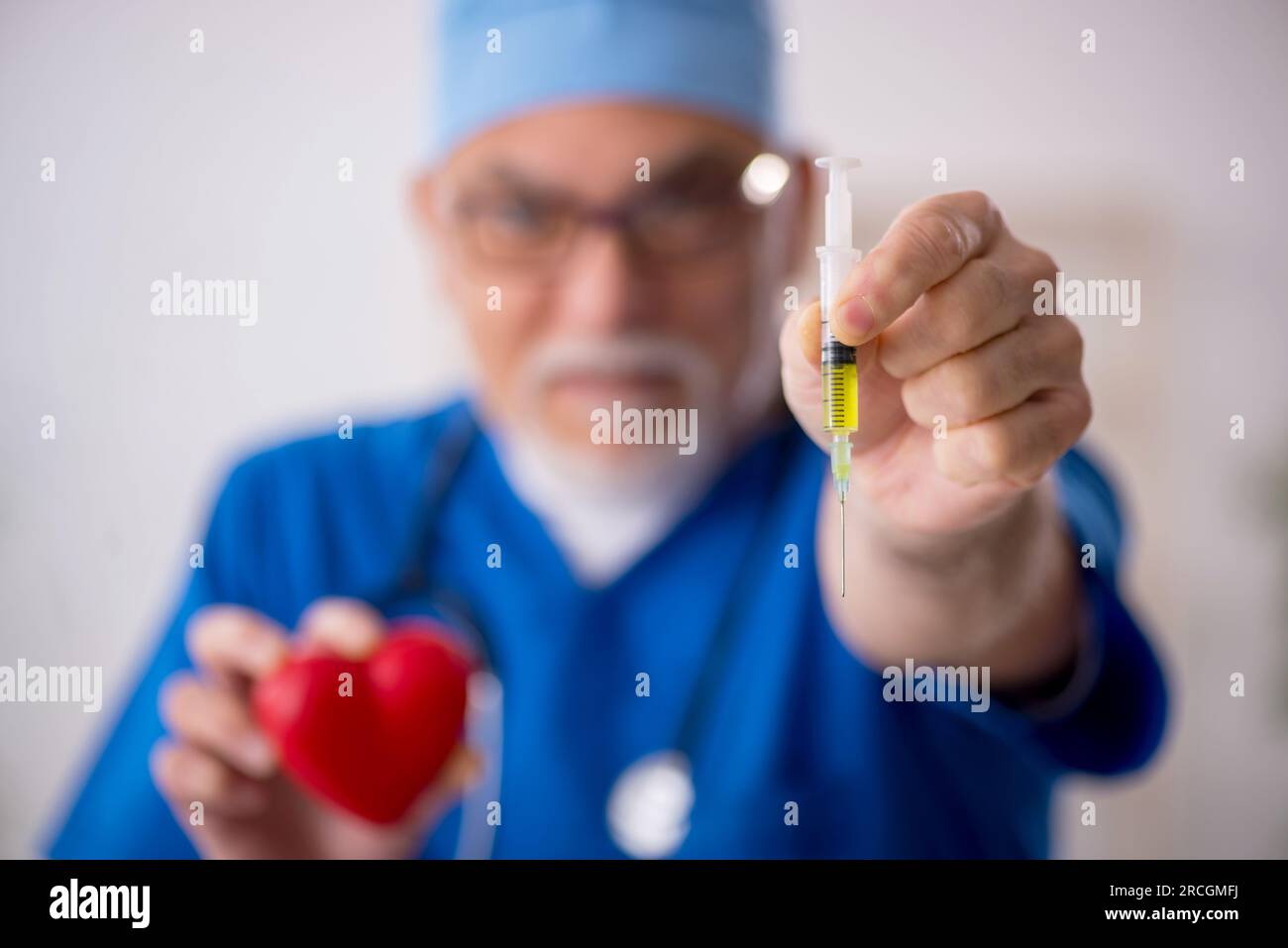 Old doctor cardiologist working in the clinic Stock Photo - Alamy