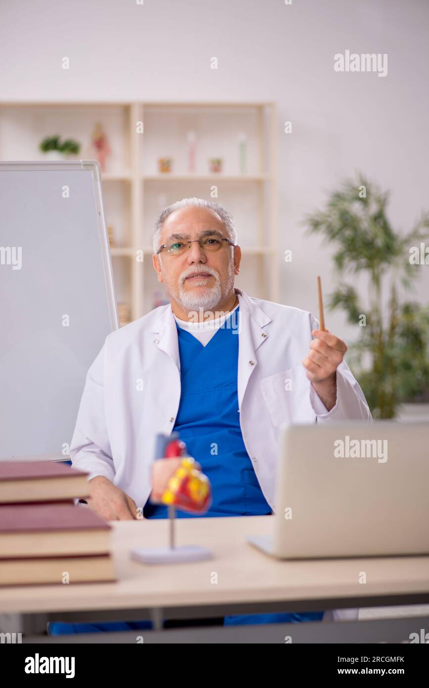Old doctor cardiologist working at the hospital Stock Photo - Alamy