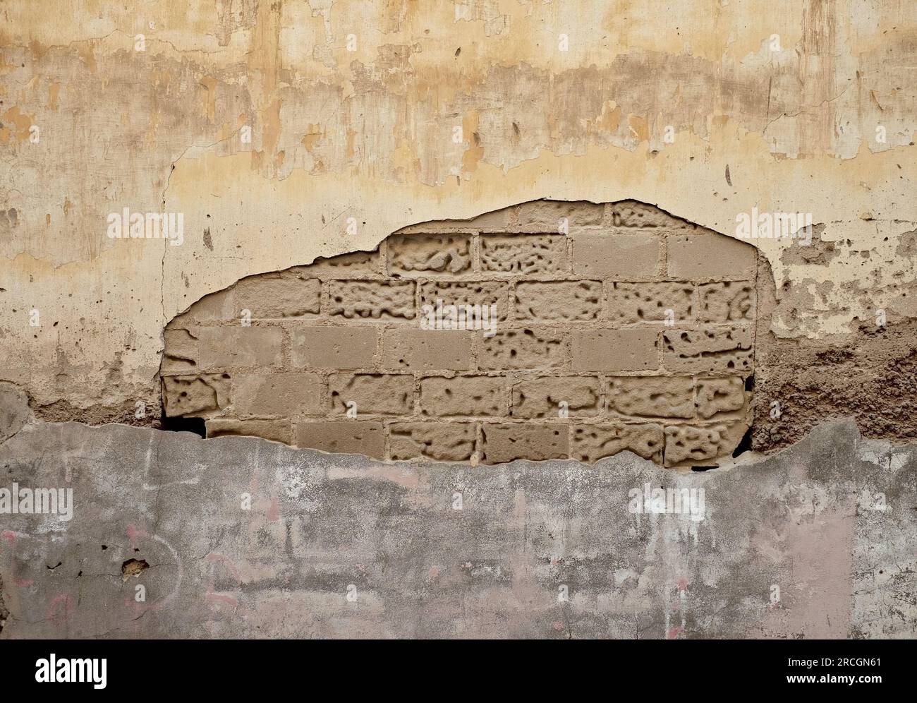 Vintage pastel colored wall with plaster exposing an old sand brick and ...