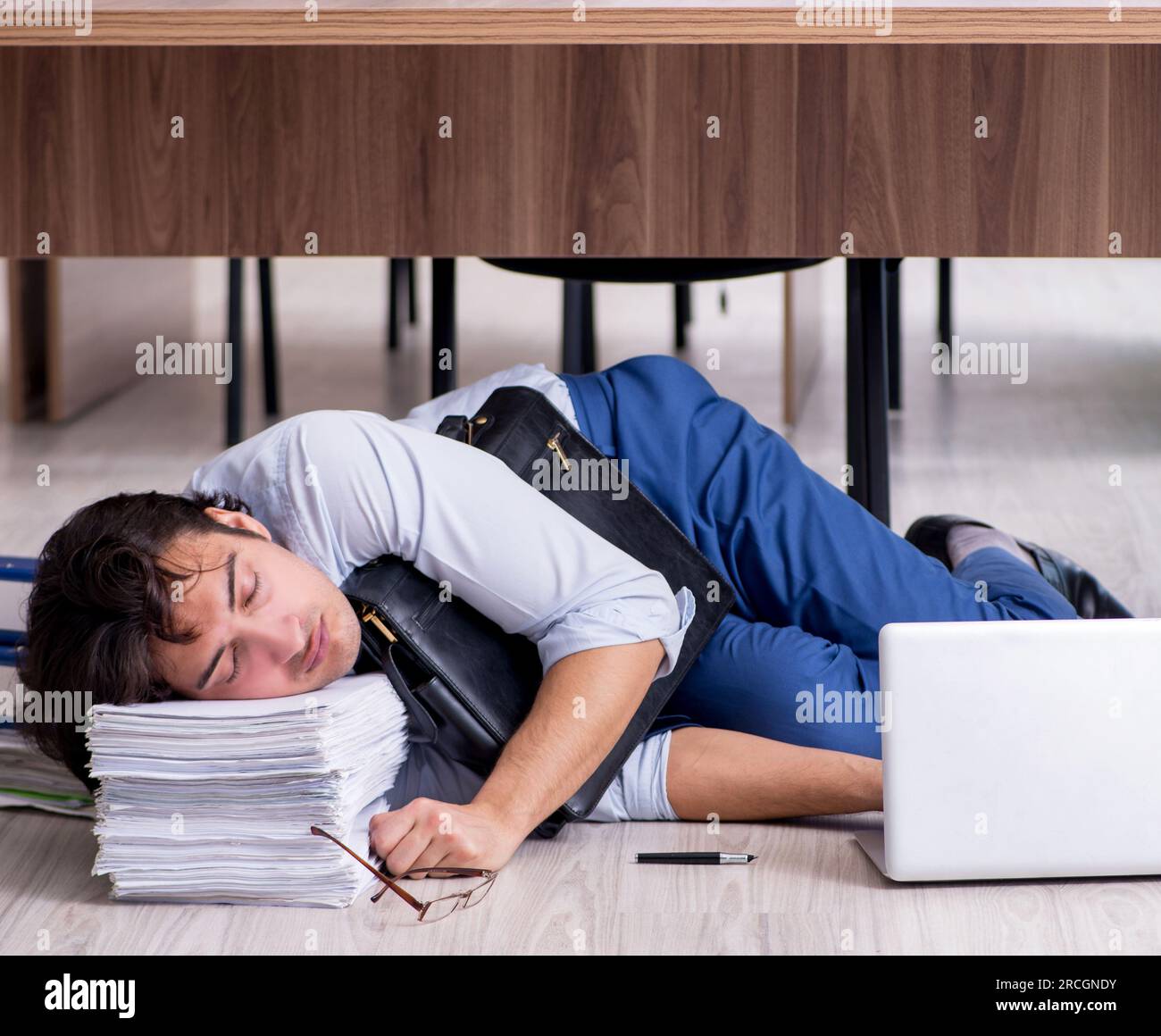 The young male employee and too many work in the office Stock Photo - Alamy
