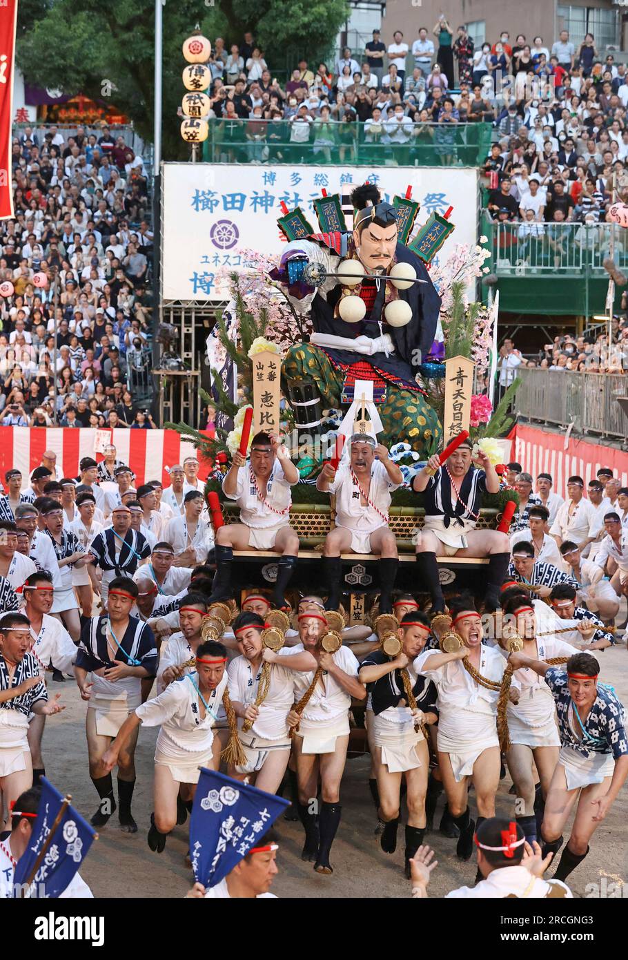 A Yamakasa float rushes into Kushida Jinja Shrine during Hakata Gion ...