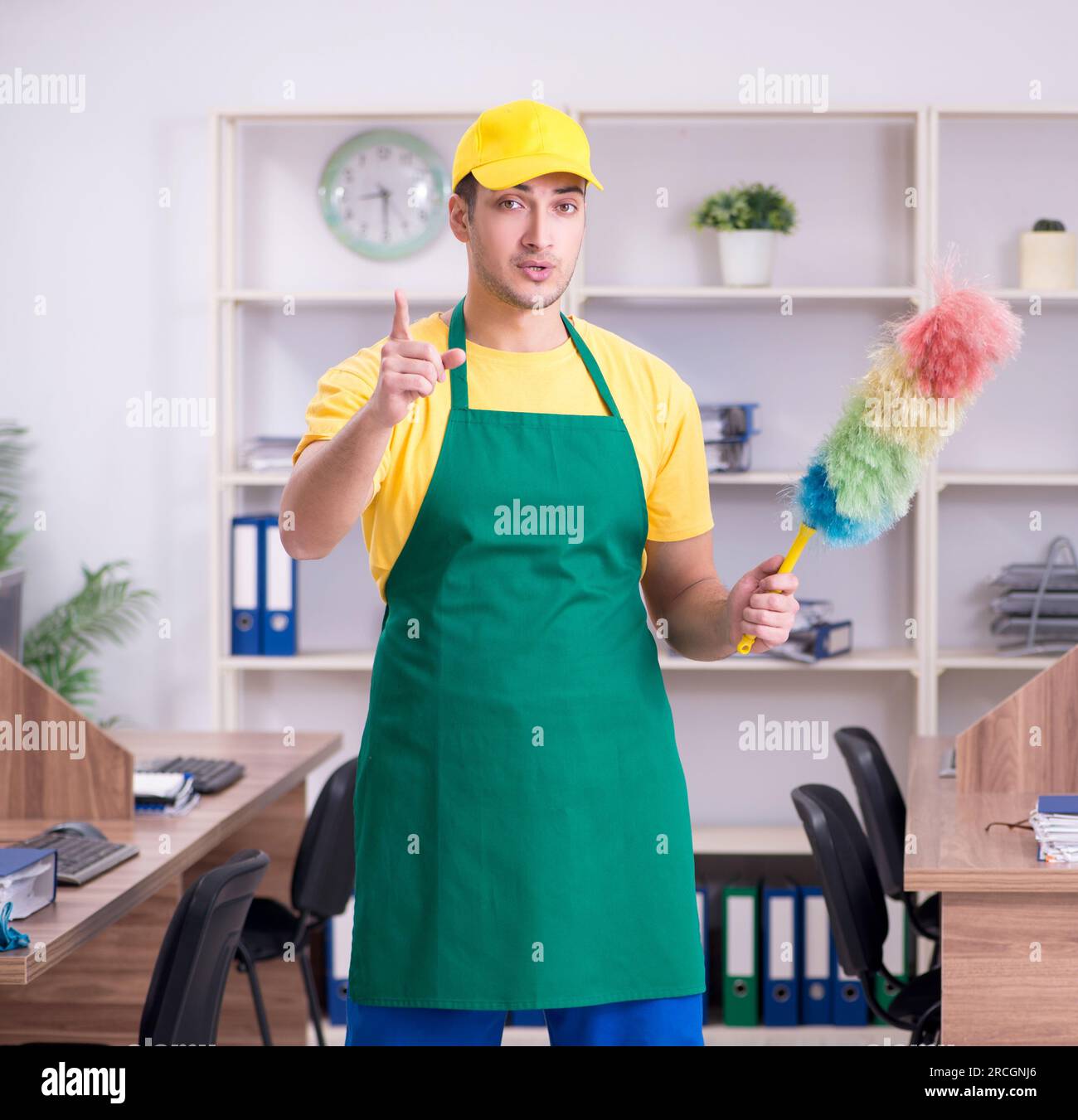 The young male contractor cleaning the office Stock Photo - Alamy