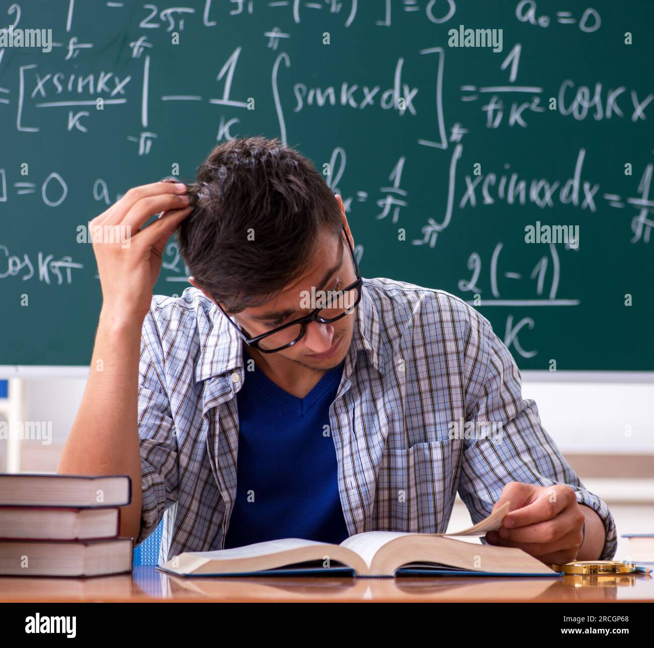 The young male student studying math at school Stock Photo - Alamy