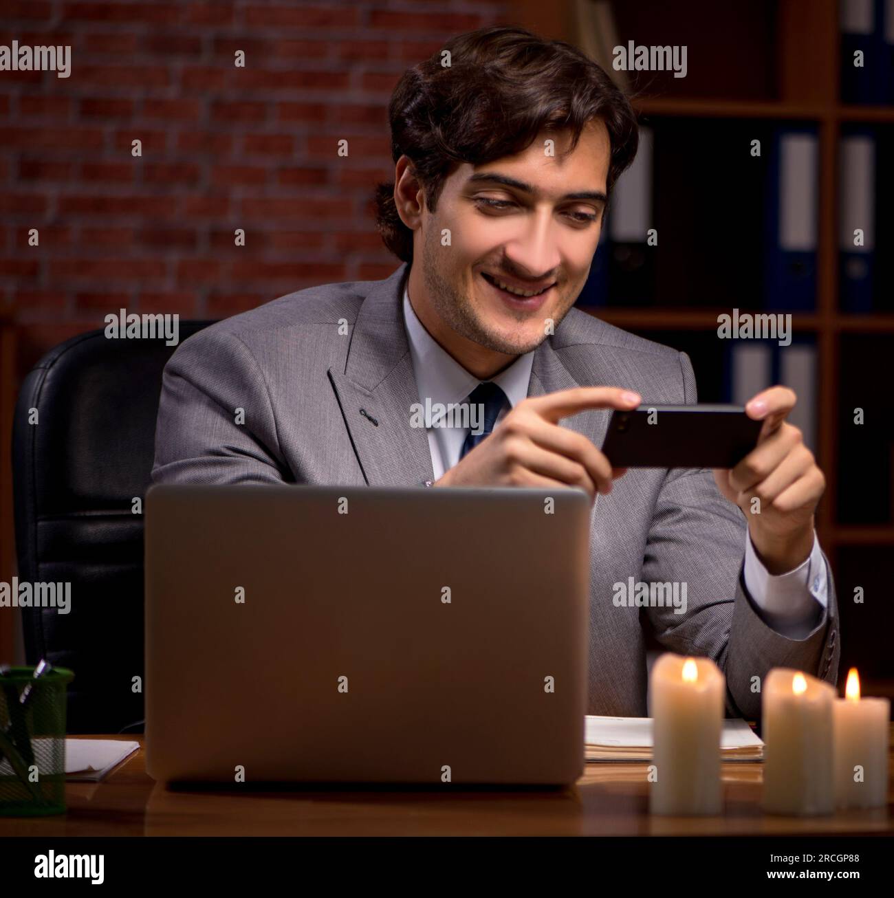 The businessman working late in office with candle light Stock Photo ...