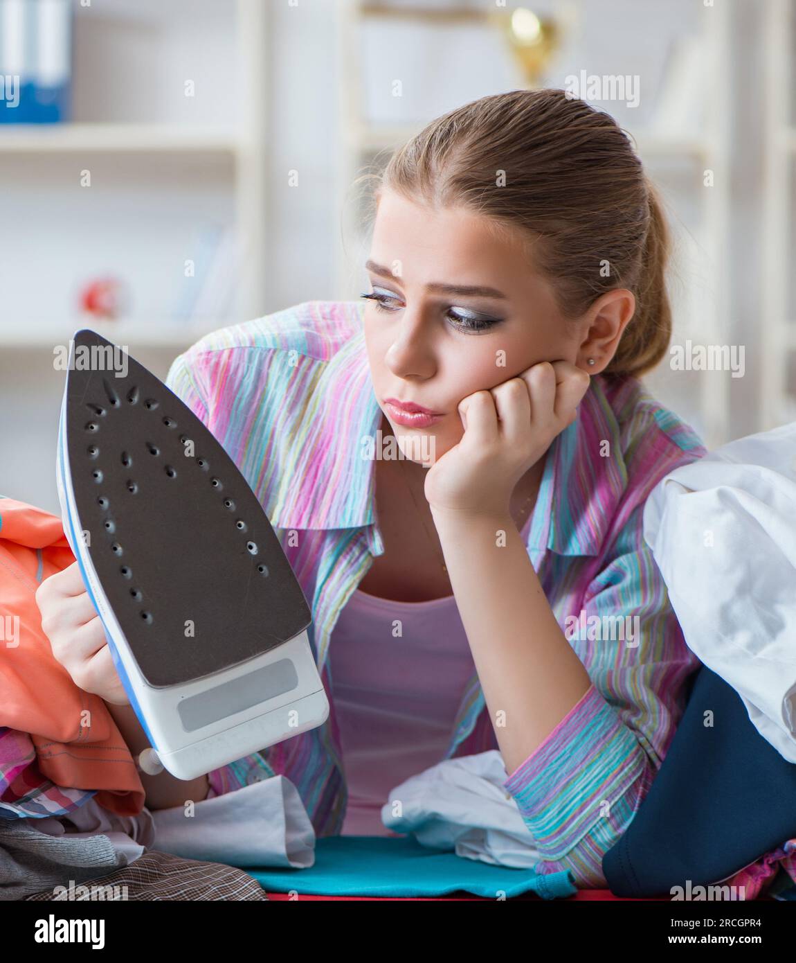 The sad woman ironing clothing at home Stock Photo - Alamy