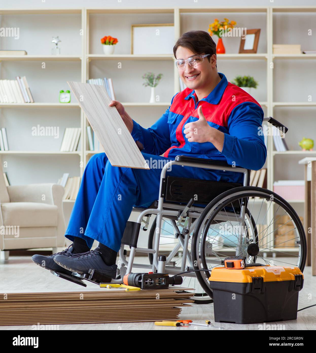 The disabled man laying floor laminate in office Stock Photo - Alamy