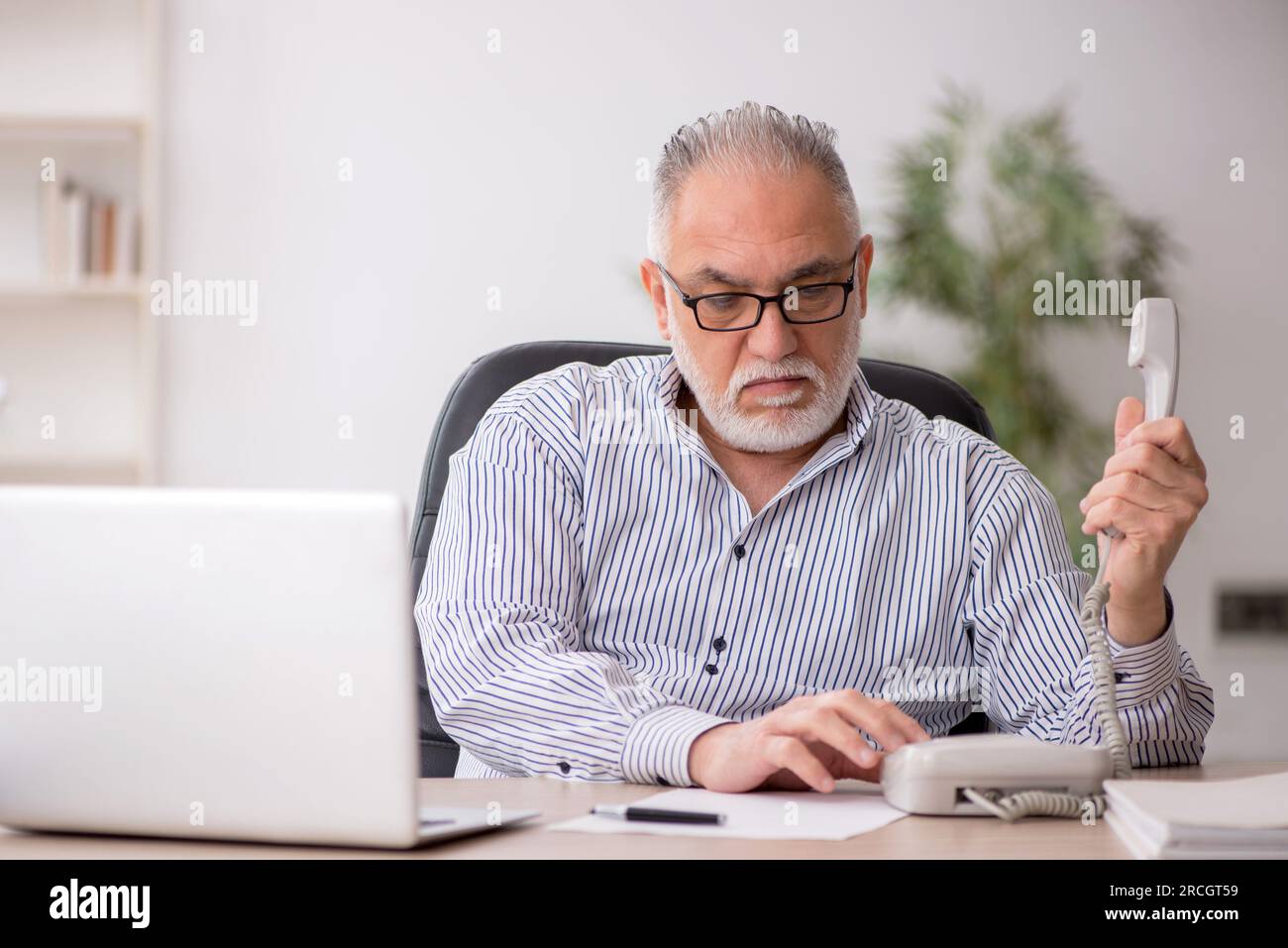 Old employee working in the office Stock Photo - Alamy