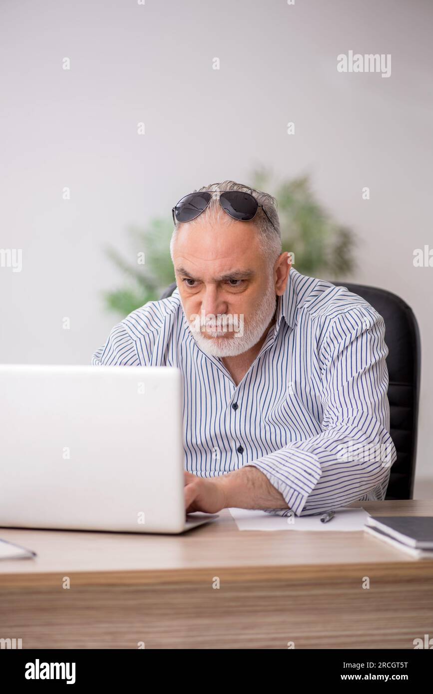 Old employee working in the office Stock Photo - Alamy