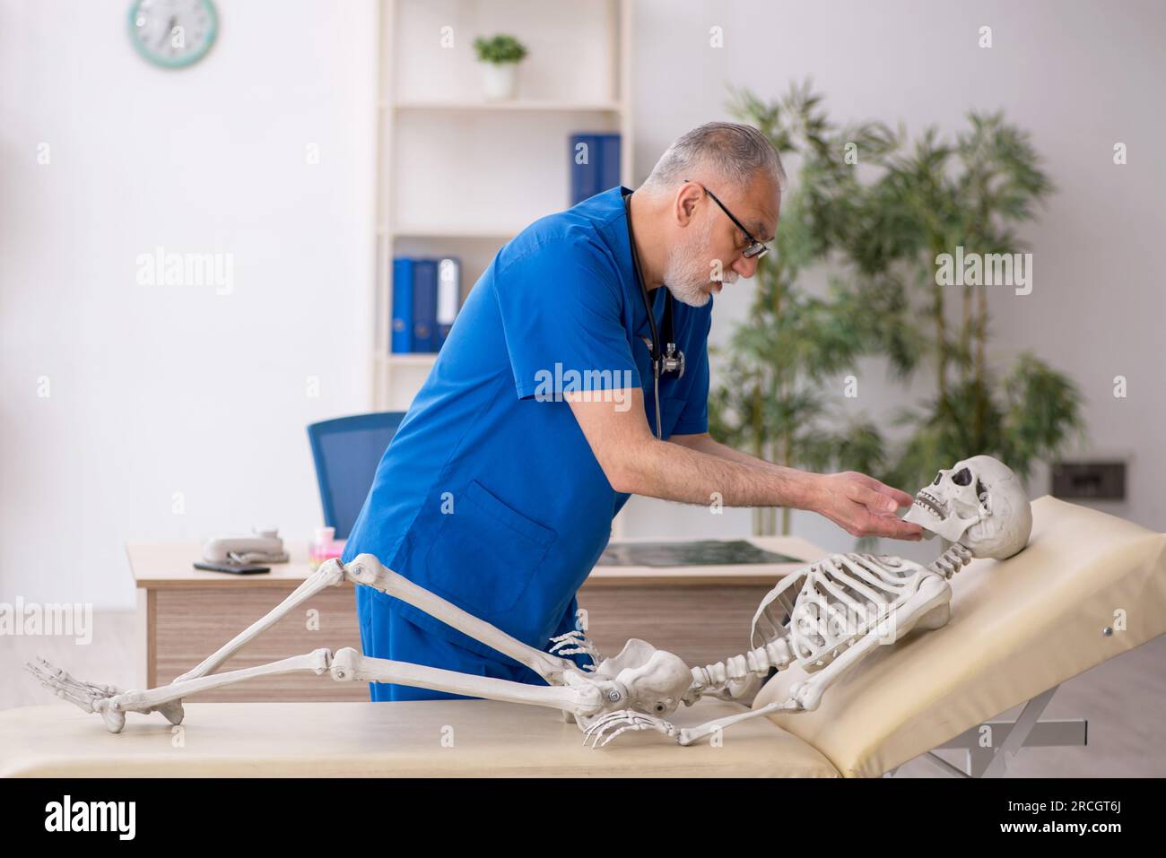 Old doctor examining skeleton at the hospital Stock Photo - Alamy