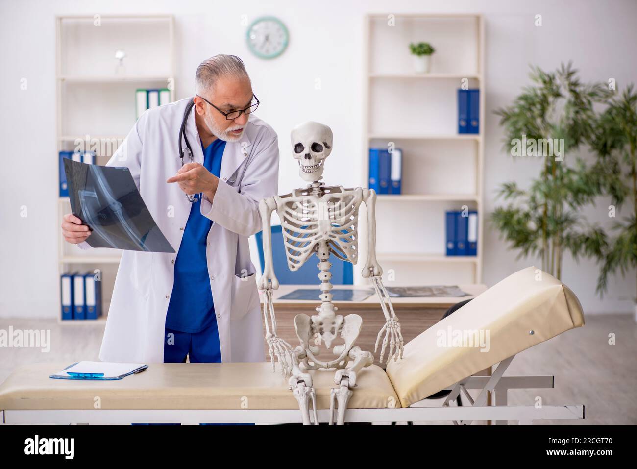 Old doctor examining skeleton at the hospital Stock Photo - Alamy