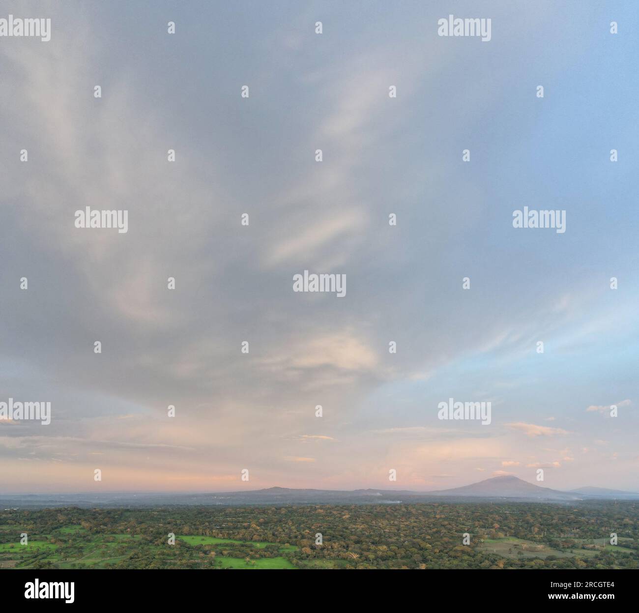 Soft pink color sunset sky background over volcano green landscape ...