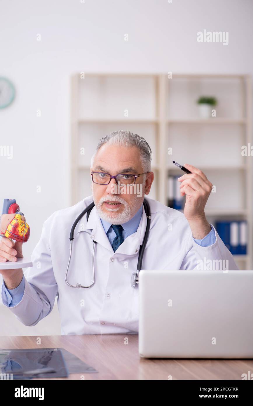 Old doctor cardiologist working in the clinic Stock Photo - Alamy