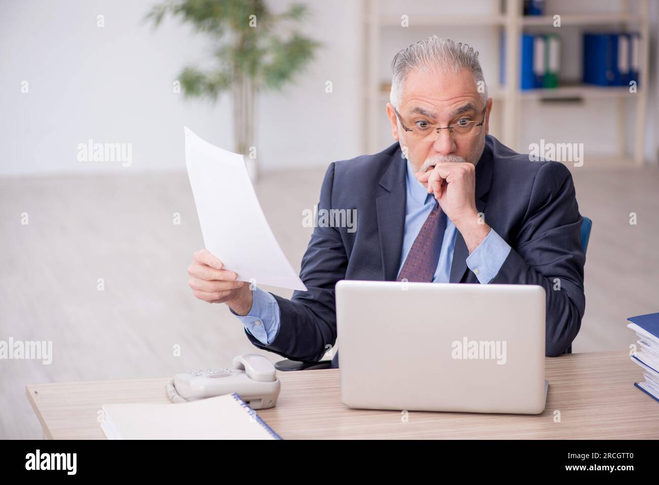 Old employee working at workplace Stock Photo - Alamy